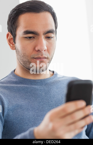 Young man text messaging on mobile phone while using laptop Stock Photo ...