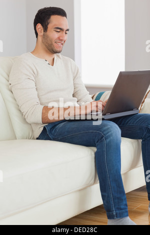 Happy man using tablet computer while sitting on sofa at home Stock ...