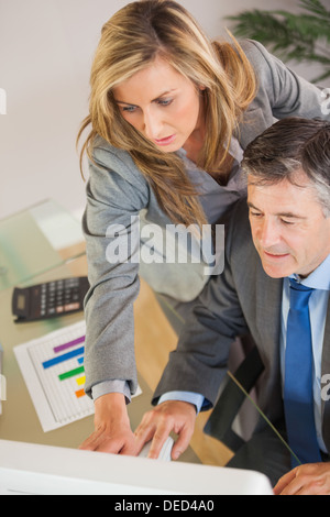 Office colleagues looking at computer Stock Photo - Alamy
