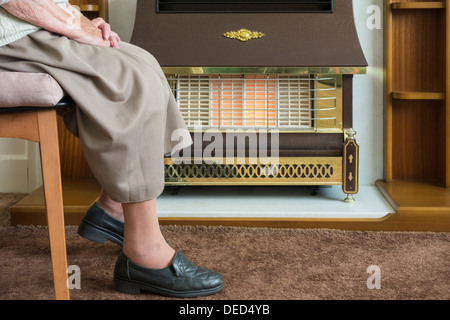old woman sitting by gas fire Stock Photo - Alamy
