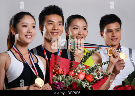 Group of young athletes wearing medals holding trophy Stock Photo - Alamy
