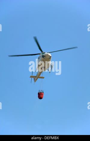 Helicopter water bomber drenching a forest fire Stock Photo - Alamy