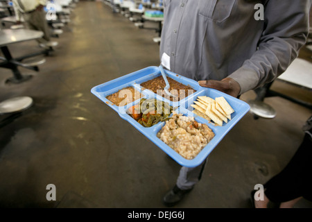 A prison security guard hold up a tray with food choice given to ...