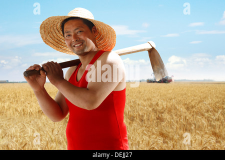 Farmer carrying hoe on his shoulder standing in field Stock Photo - Alamy