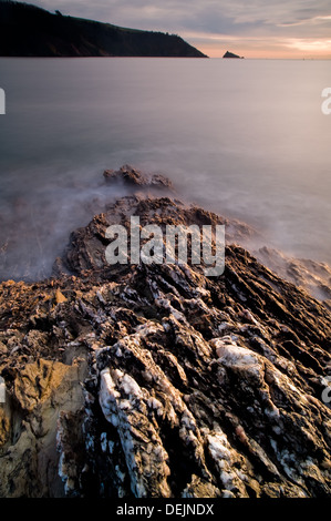 Rocky seascape at sunset at Ladies Cove Dartmouth Devon England Stock ...