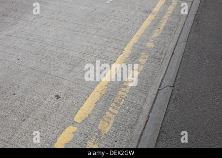 A close up of double yellow line kerbside road markings Stock Photo - Alamy