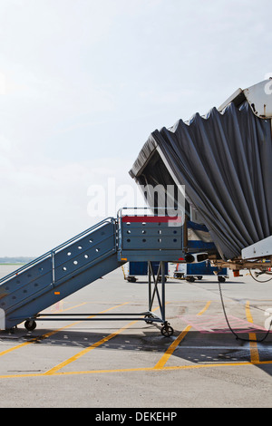 Passenger boarding bridge with stairs at airport gate. Ground ...