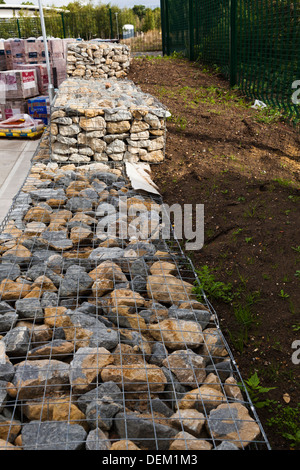 earth retaining wall of gabion mesh caged stones Stock Photo - Alamy