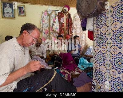 Moroccan tailor hand sewing a traditional Berber djellaba in his ...