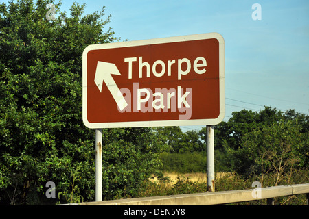 A brown road sign directing traffic to landmarks and attractions in ...