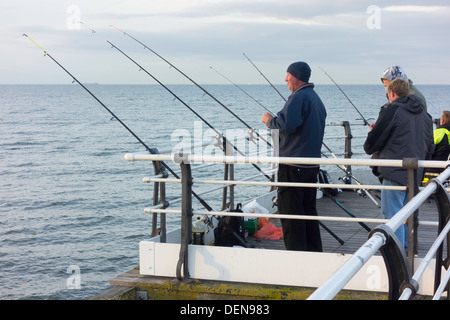 Anglers fishing from the end of Saltburn Pier at high tide on a warm ...