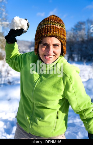 Pretty young woman playing snowballs Stock Photo - Alamy