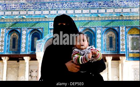 Mother Wearing Traditional Blue Burqa Sitting On The Ground In A Park ...