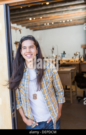Young happy man in Santa Claus hat, decorates the Christmas tree with ...