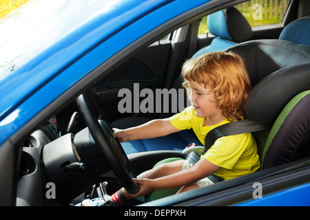 Children pretend driving car sitting on front vehicle seats Stock Photo ...