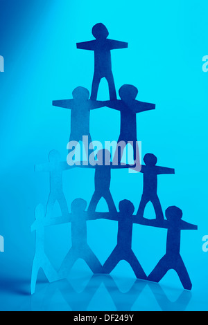 Unity concept. People building pyramid of colorful cubes at wooden ...