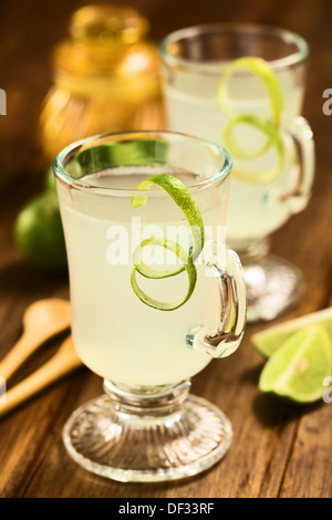 Glass of fresh lemonade and limes on color background Stock Photo - Alamy