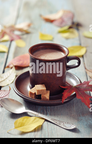 cup of coffee,cocoa in yellow leaves on a wooden background. View from ...
