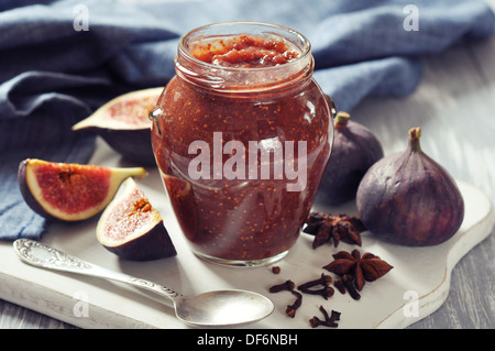 Fig jam in glass jar and fresh figs on white wooden background, top ...