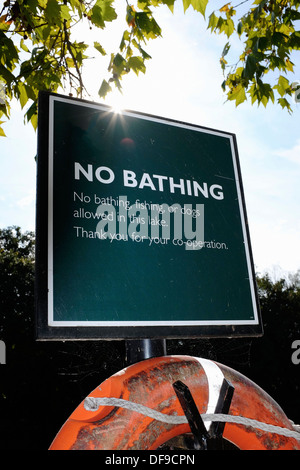 Warning sign for deep water and strong currents next to a lake in the ...