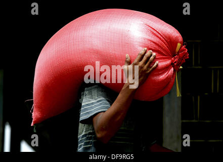 A man carrying a heavy bag of rice on his head in Fort Kochi, Kerala ...