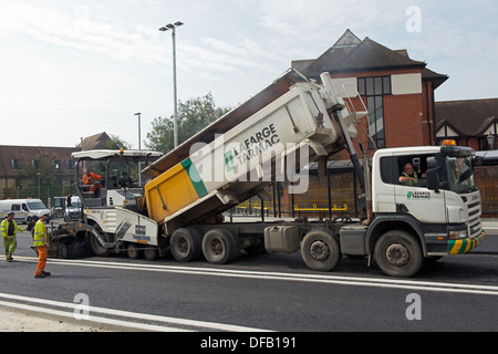 Tipper lorry and Tarmac laying machine with road roller and workmen ...