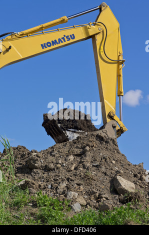 Yellow excavator arm and hydraulic pistons close view against blue sky ...