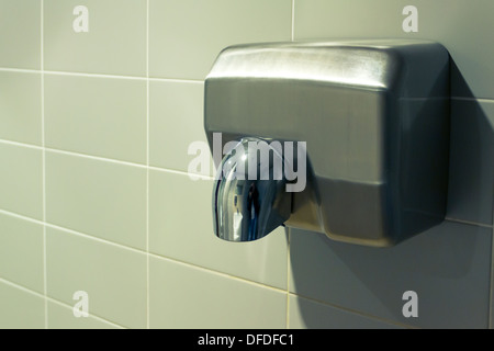 Silver hand dryer on a grey tiled wall Stock Photo - Alamy