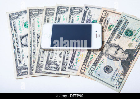 Cash for your iphone. U.S. currency and a used iphone on a white ...