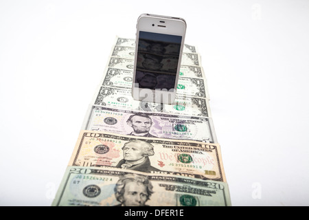 Cash for your iphone. U.S. currency and a used iphone on a white ...