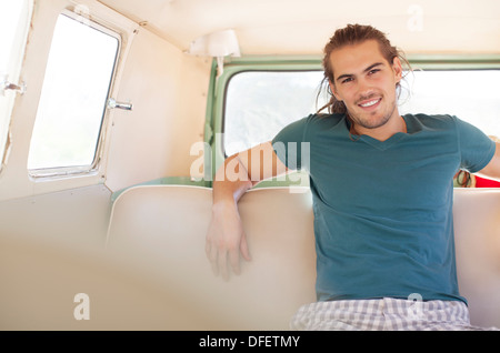 Man sitting in back of van smiling Stock Photo - Alamy