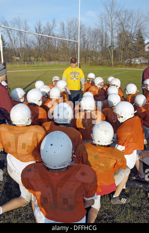Football coach meeting with team to discuss finer points of the game ...