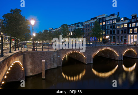 Illuminated canal bridges at night, Amsterdam, Netherlands Stock Photo ...