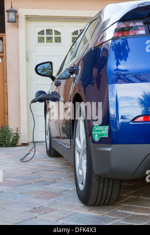 Plug-in electric car with carpool sticker parked in driveway, with ...