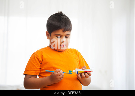 Boy squeezing toothpaste on a toothbrush Stock Photo - Alamy