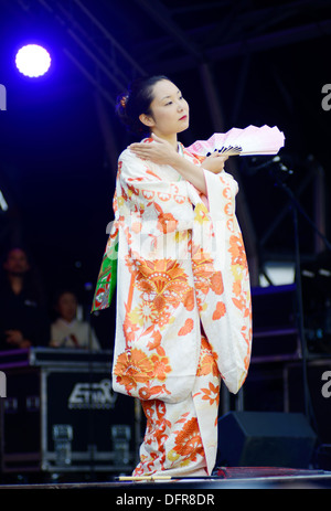A Japanese geisha wearing a kimono, performs a traditional fan dance at ...
