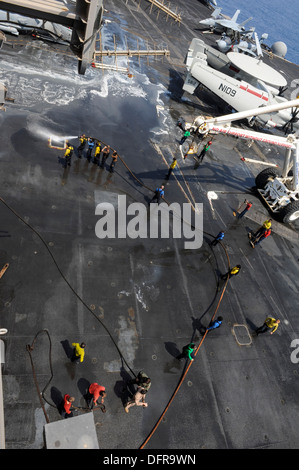 U.S. Navy sailors wash down the flight deck of the aircraft carrier USS ...