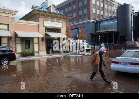A worker walks through a flooded road in Mill Valley, Calif., Monday ...
