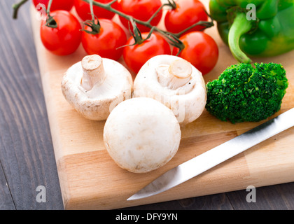 Vegetables for salad, knife and cutting board on the table. Preparation ...