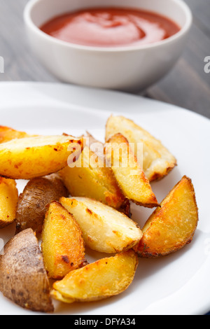 Oven baked potato wedges with sauce over light stone background. Top ...