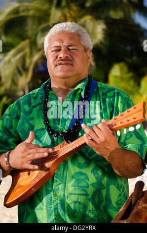 pacific island man plays his ukulele for a young woman on a hawaii ...