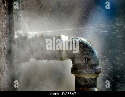 Old rusty pipe with leak and water spraying out under pressure leaky ...