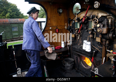 A female engine driver working the footplate of a steam locomotive on ...