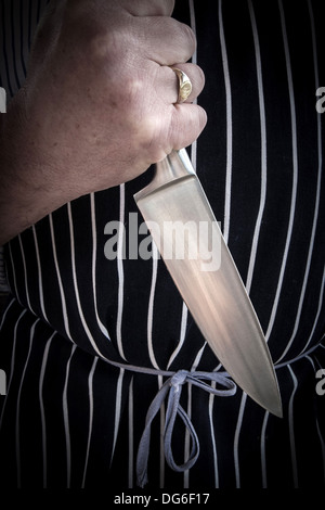 Man holding a chef's knife and about to cut meat for beef stake Stock ...