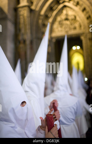 Row of hooded penitents entering Seville's Cathedral, Spain Stock Photo ...