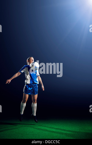 Young female football player controlling football using thigh Stock ...