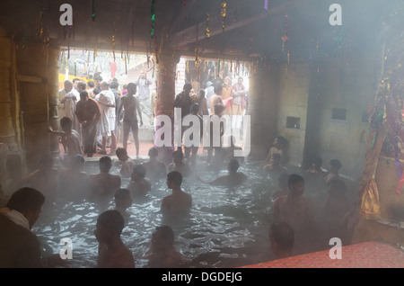 Hindu pilgrims bathing in hot springs below the Badrinath temple, India ...