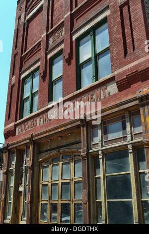 Abandoned multi-story red brick factory building with broken glass ...
