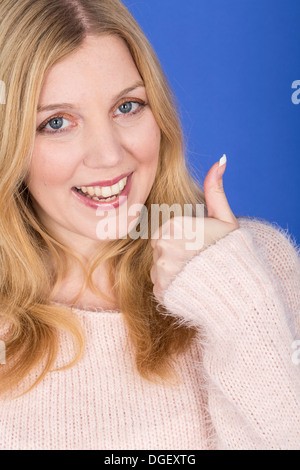 Young woman making "thumb's up" sign Stock Photo - Alamy