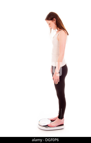 a girl on a weighing scale, disappointed of loosing to too little ...